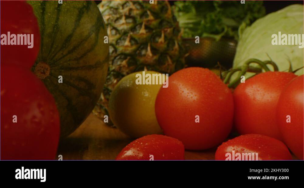 Pushing through composition of fruits and vegetables, sliding over ...