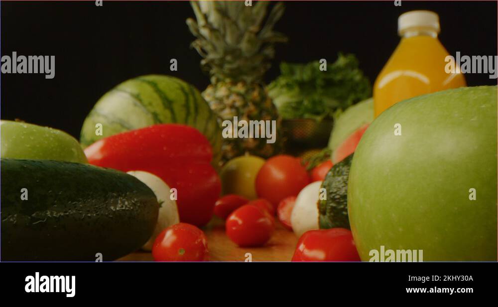 Pushing through composition of fruits and vegetables, sliding over ...