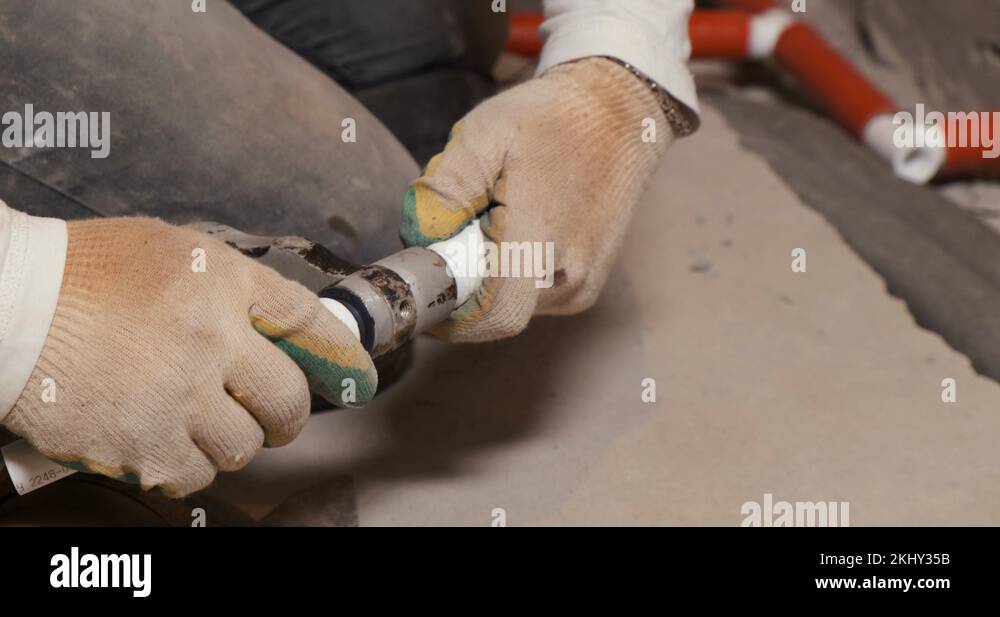 Close-up of male plumbing hands, soldering plastic pipes, installs ...