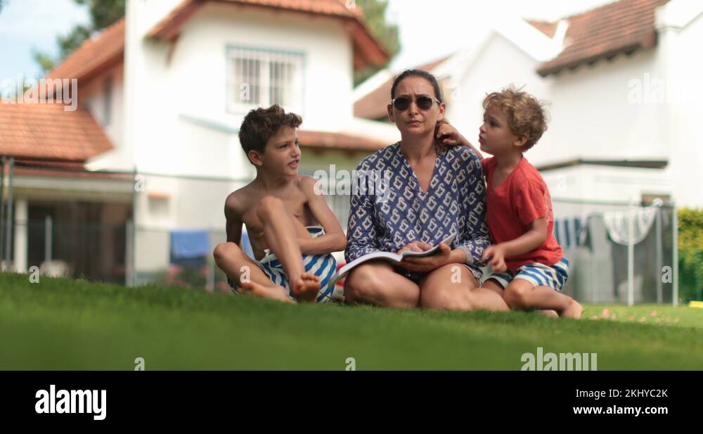 Mother tutoring child son in backyard home. Mom teachers kid to read ...