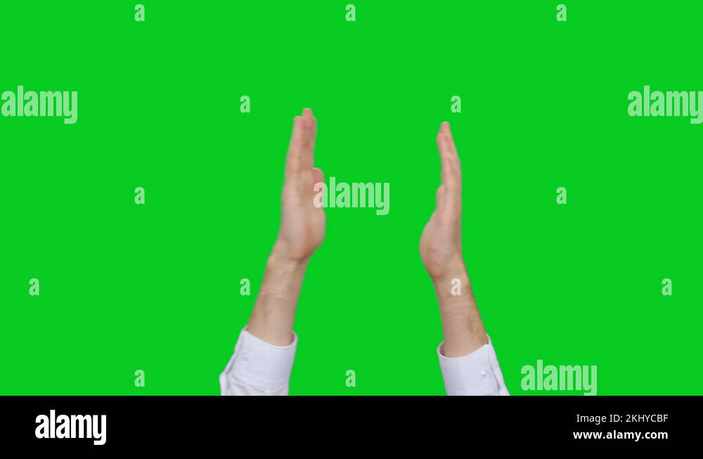 Young male hands raised and clapping against green screen background ...