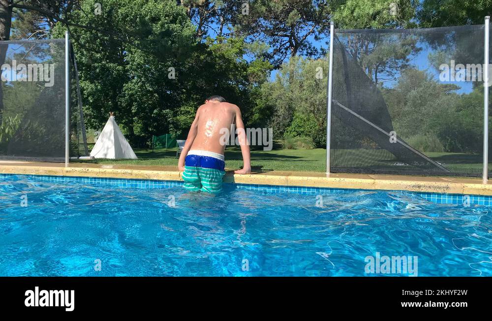 Boy lifting body from poolside. Child getting out of swimming pool ...
