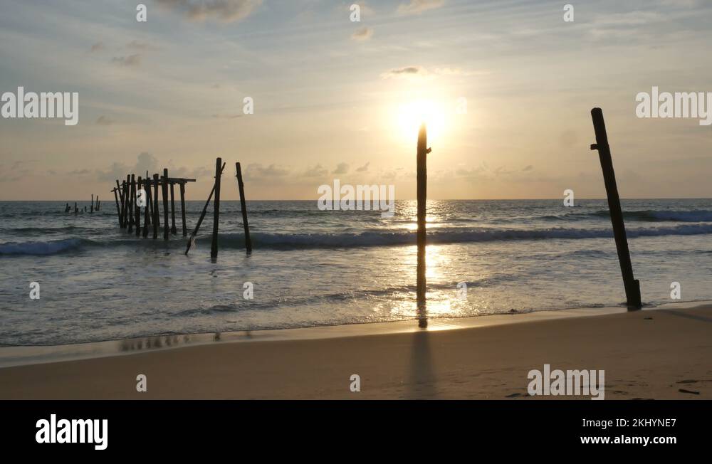 moving wave to sand sea beach , ruin rusty steel pole of old harbor ...
