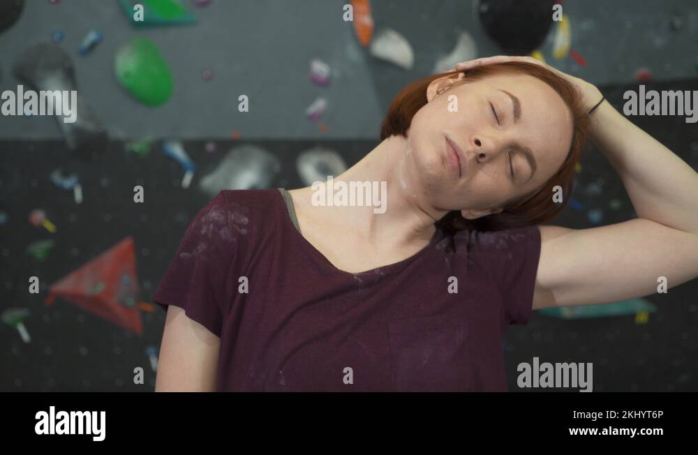 Young woman mountaineer does a stretch before training on a climbing ...