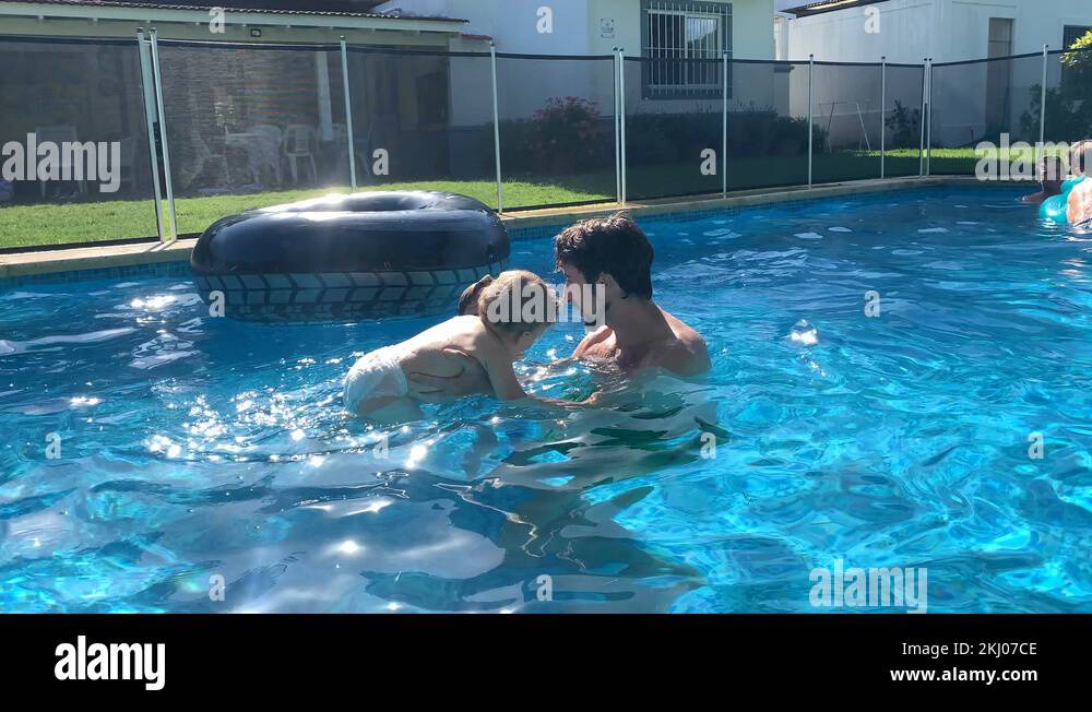 Father and baby bonding together at the swimming pool. Dad holding ...