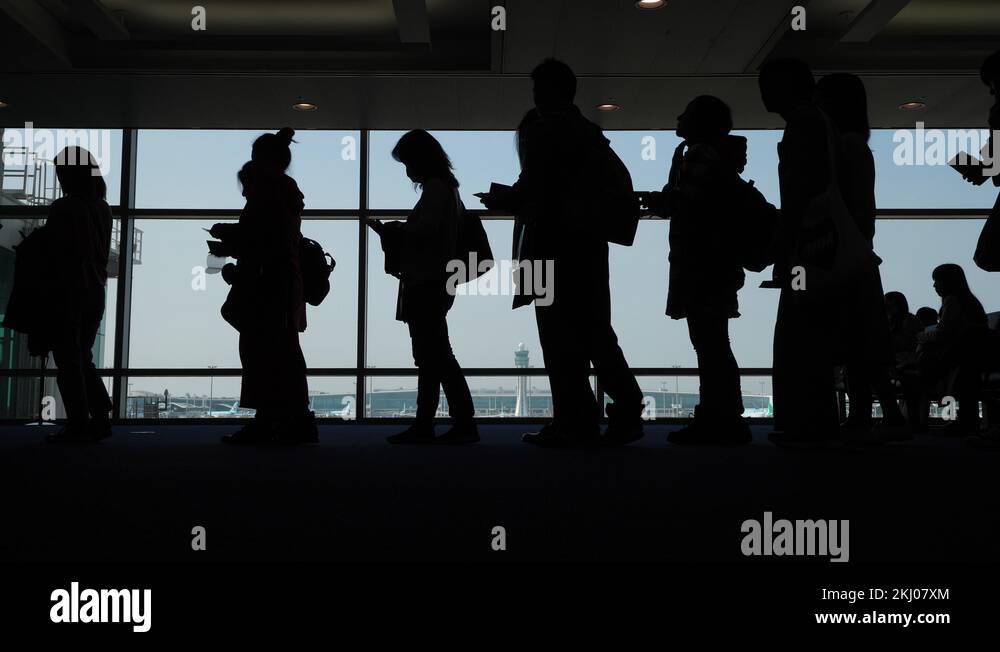 Queue to boarding gate slowly move, people stand in line, silhouetted ...