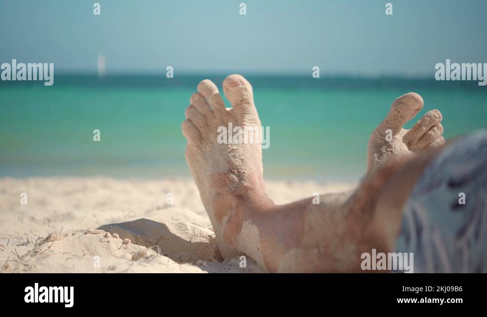 Guy Relaxing Sandy Beach In Sunbed.Man Lying On Beach.Legs On Resort ...