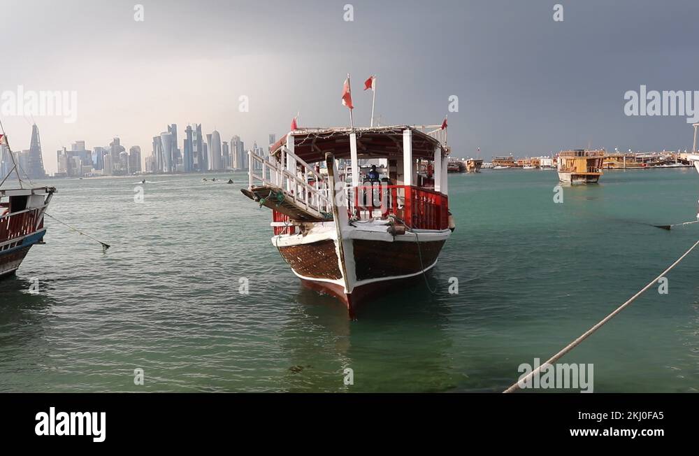 A traditional wooden boat approaching at the Corniche in Doha, Qatar ...