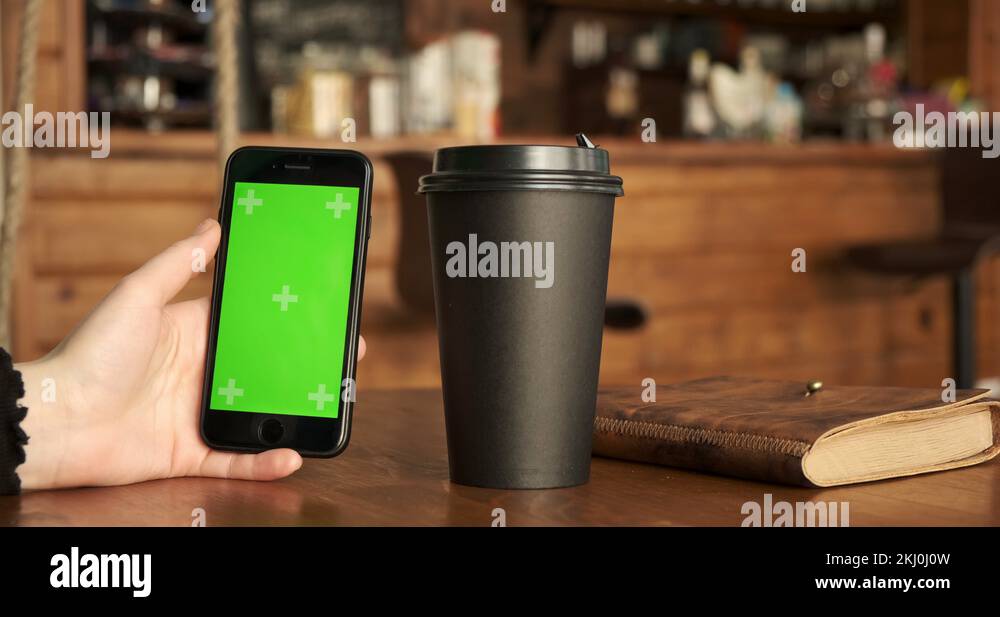 Phone closeup green screen swipe. chroma key mobile bar coffee shop ...