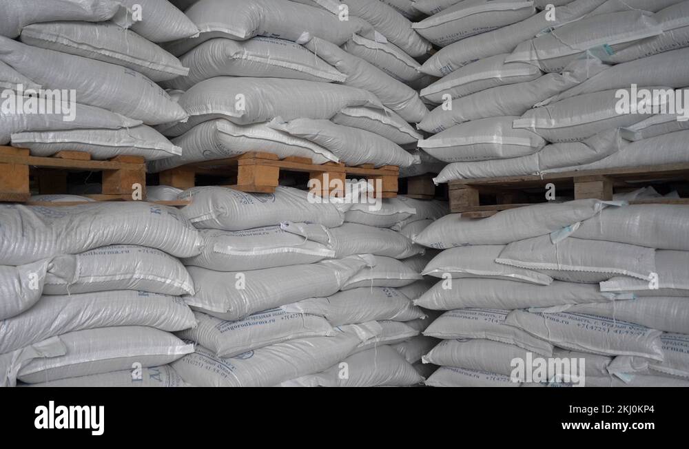 Production warehouse with folded white sacks of feed for rural animals ...