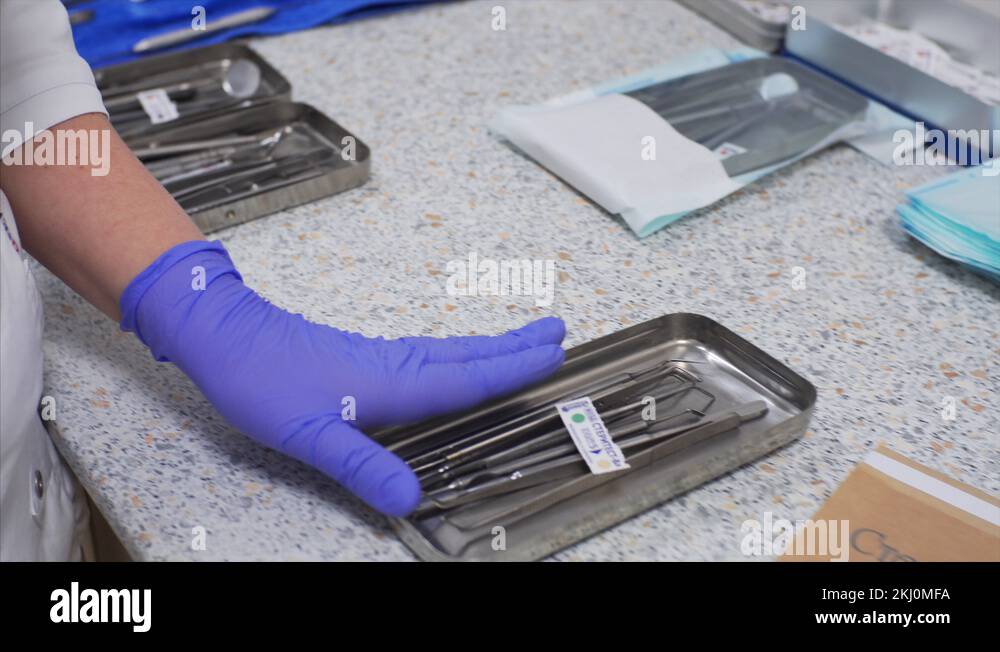 Nurse writes a date of instruments sterilization on envelope. Dental ...