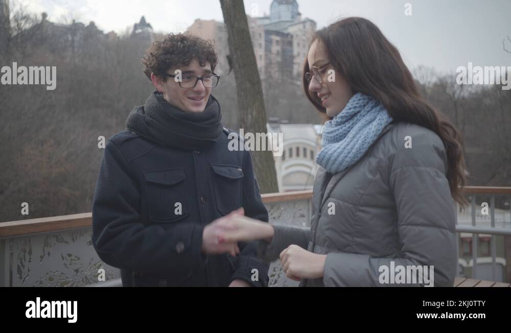 Shy nerd Caucasian boy and girl making pinky promise gesture and ...