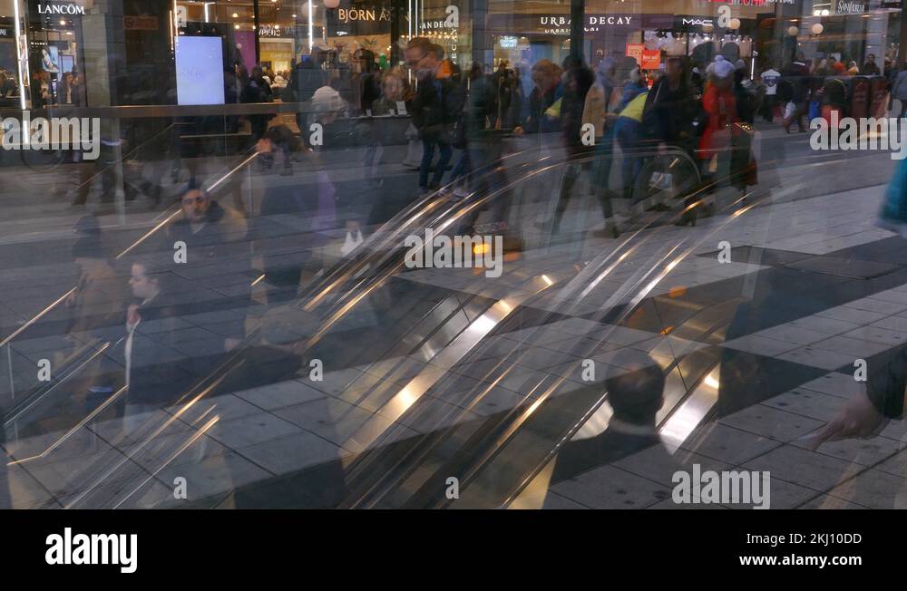 Reflection of layers of crowd of people in rush hour using escalator to ...