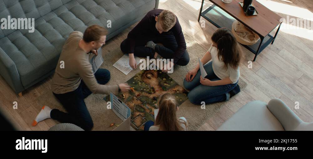 OVERHEAD Family - father, mother and two kids playing a board game ...