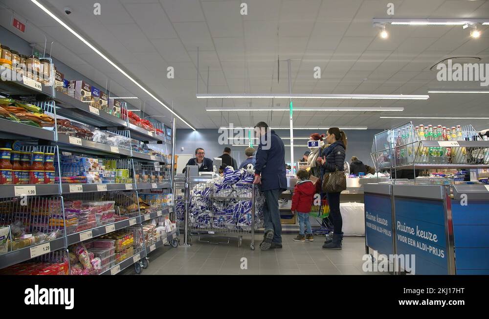 Queueing customers at cash desk in supermarket, wide shot in aisle with ...