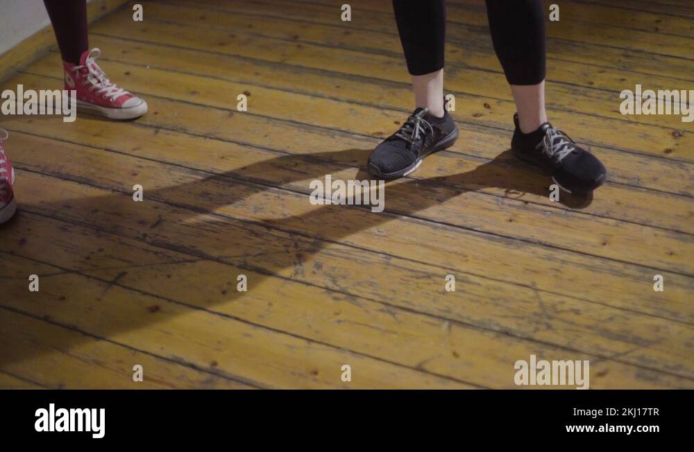 two people's feet with shoes standing , walking at a wooden floor leg ...