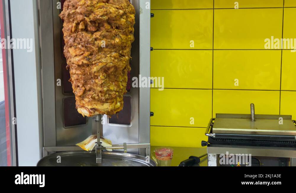 Skewered roasted chicken shawarma meat cooking on spit in fast food ...