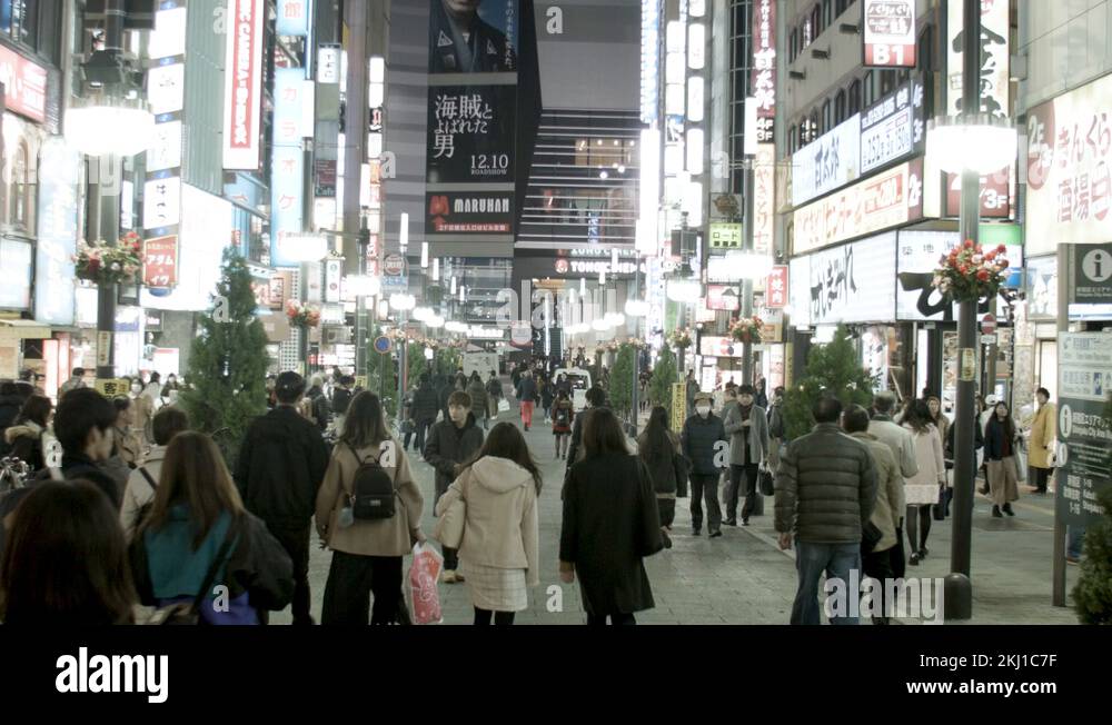 Shinjuku Kabukicho Central Rd stores at night with locals walking ...