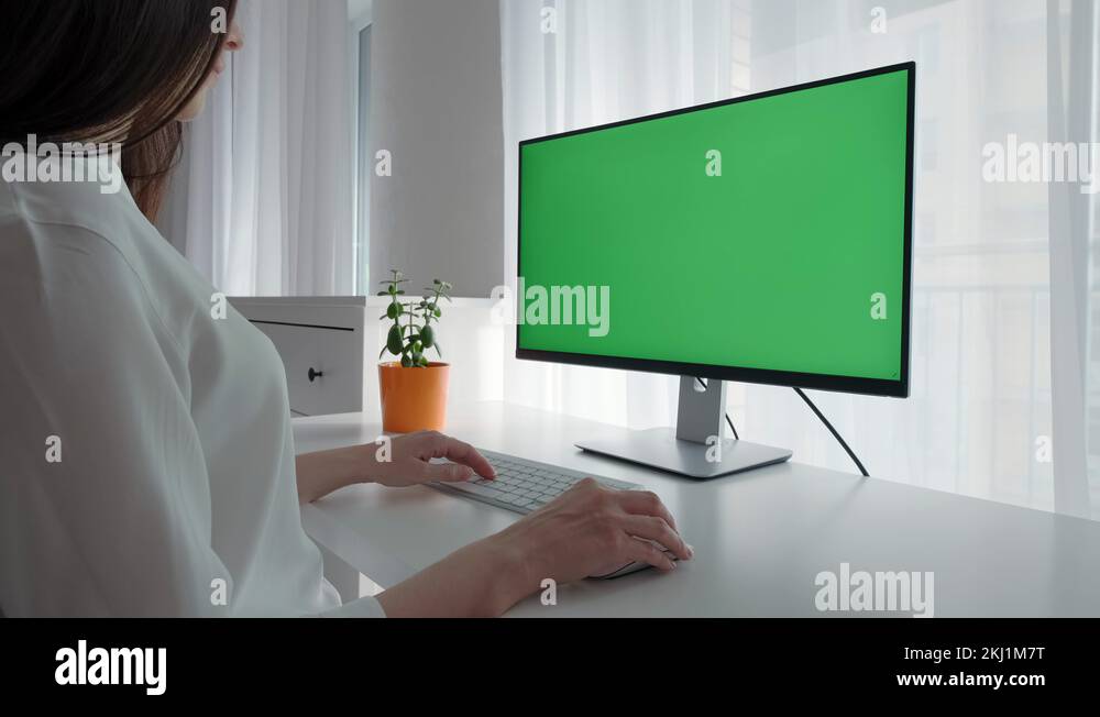 Young woman working on her personal computer, green screen mock up ...