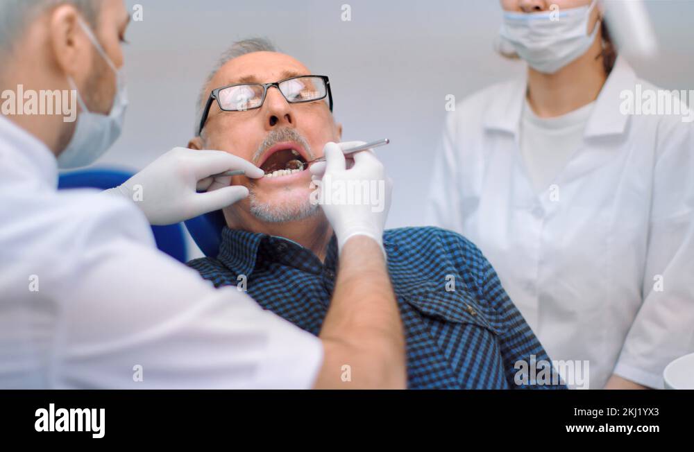 Male dentist checkup mouth cavity of aged man patient at dentistry ...