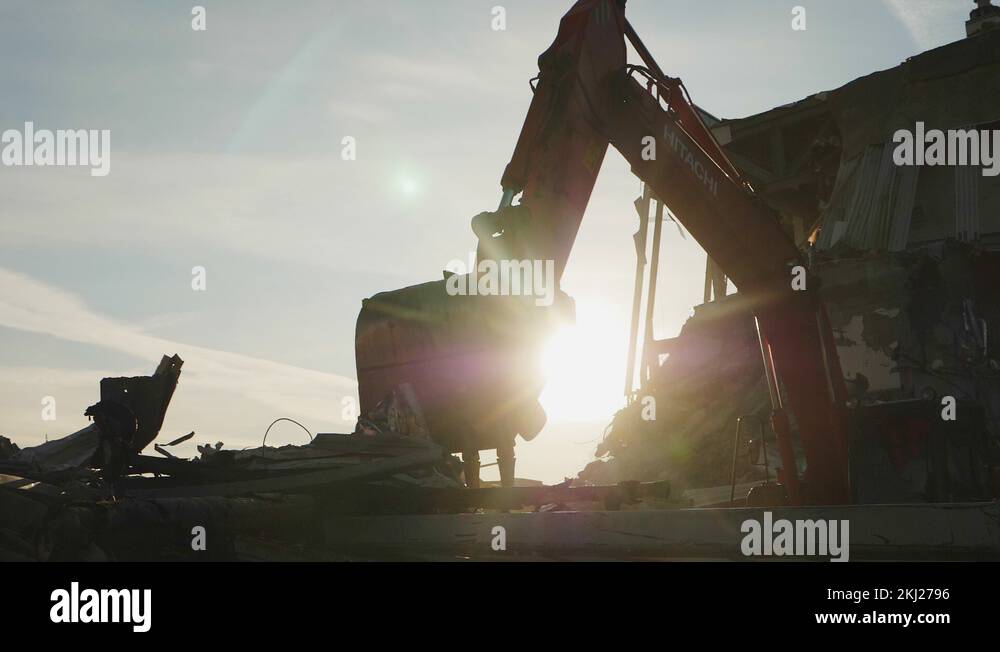 silhouette of excavator disassembling debris of old arena Stock Video ...