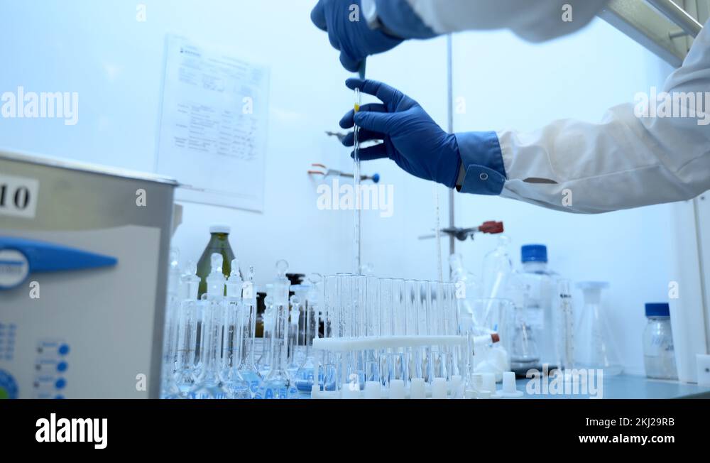 chemist hands using pipette and vial. dropping sample into test tube ...
