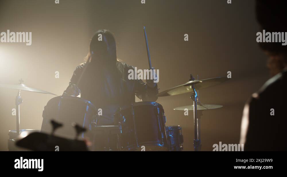 An authentic rock band is playing music in a club, guitarist and ...