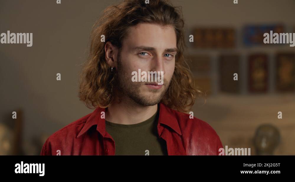 Close up view of millennial good looking man turning head and looking ...