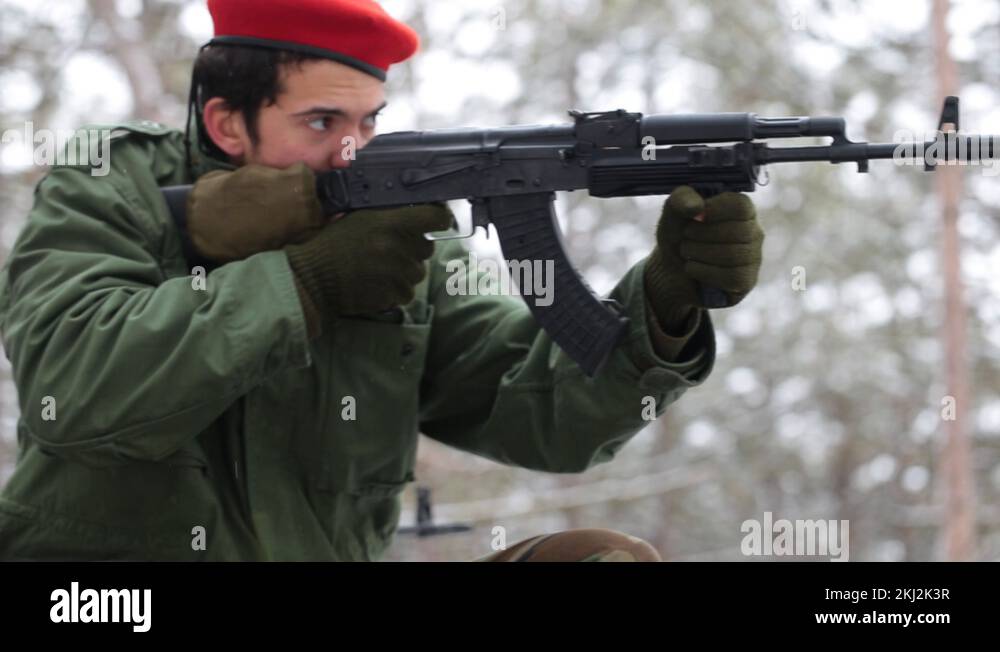 The soldier in red beret aiming their rifle and shooting at the enemy ...