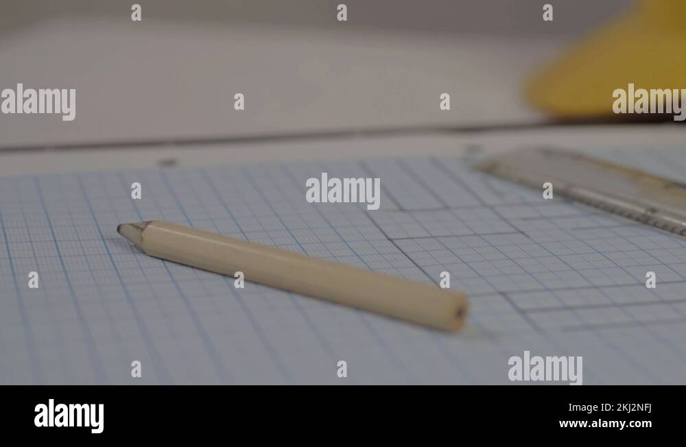 Pencil and drawings on graph paper with ruler and yellow hard safety ...