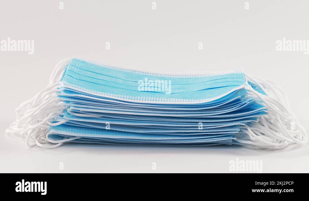 Nurses' hands remove a stack of medical masks from a white sterile ...