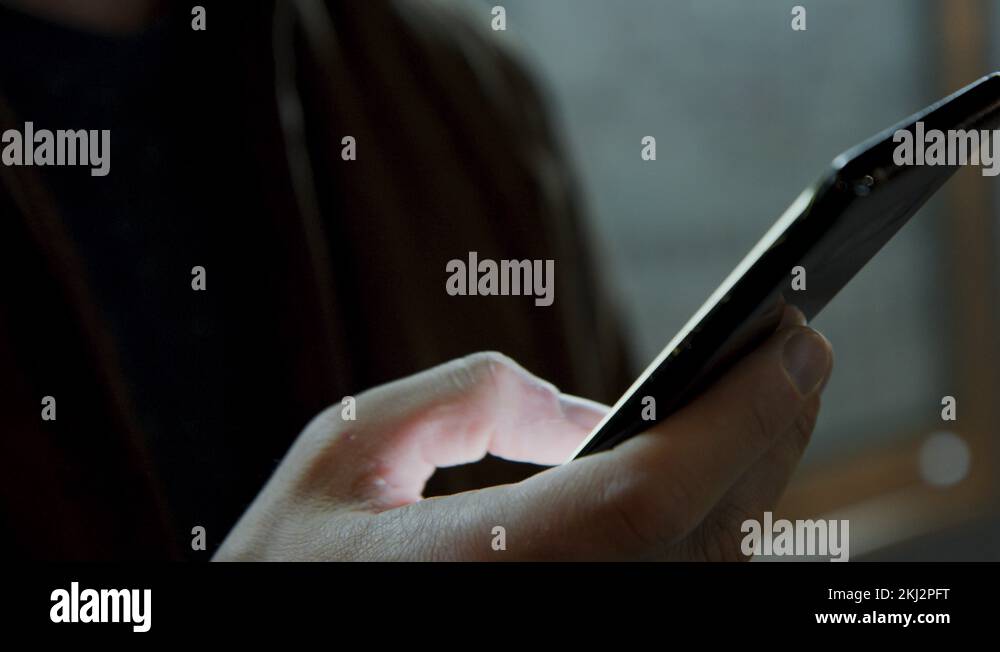 Male hands texting message on a cell phone at the night city on ...