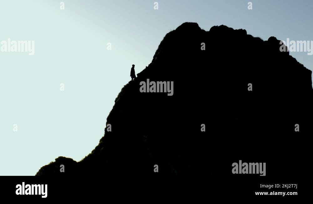 Epic Silhouette of a Man Standing On Top of A Mountain Peak With Sun ...