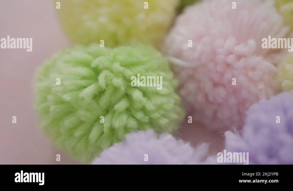 Pastel color pom poms on a pink background Stock Video Footage - Alamy