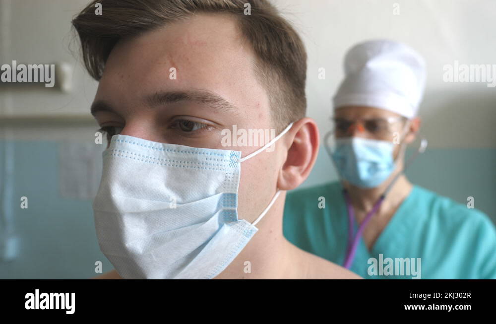 Medic listens lungs of coughing man. Doctor exams male patient with ...