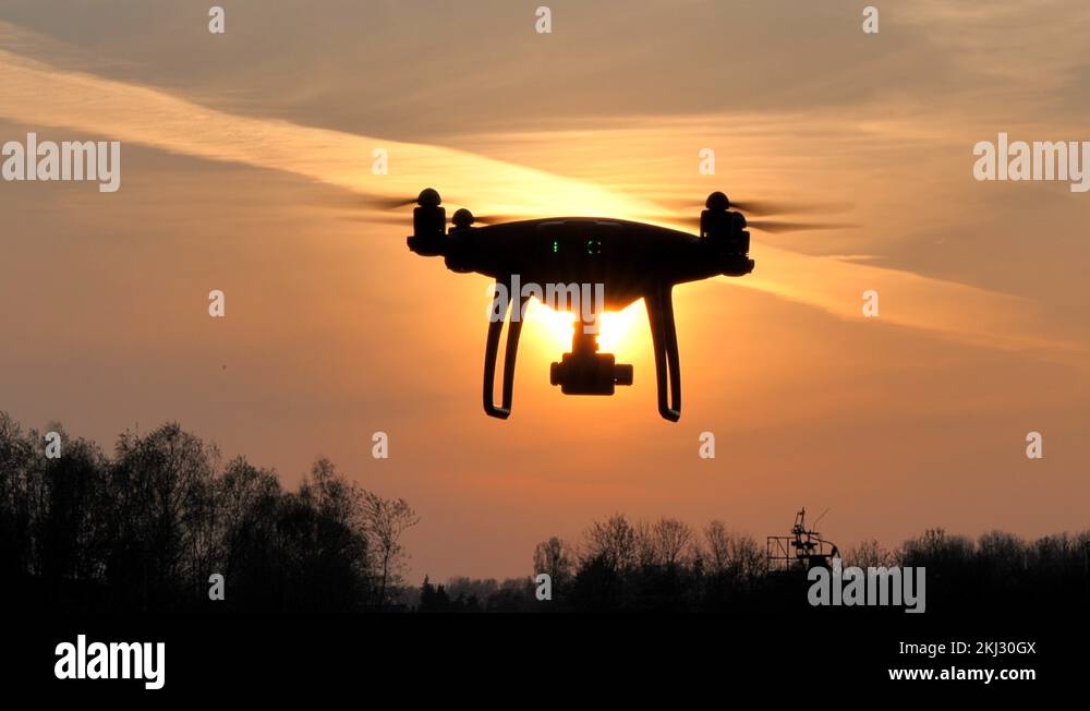 Drone Silhouette Flying in front of Sun during Sunset. Lens Flare Stock ...
