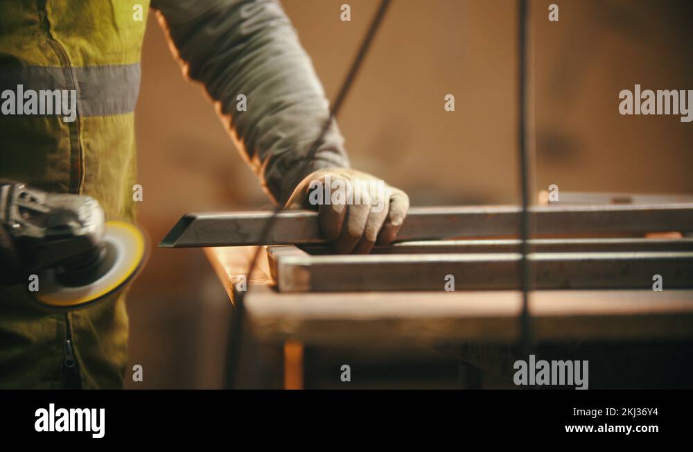 Working in the welding workshop - grinding the cut of the metal beam ...