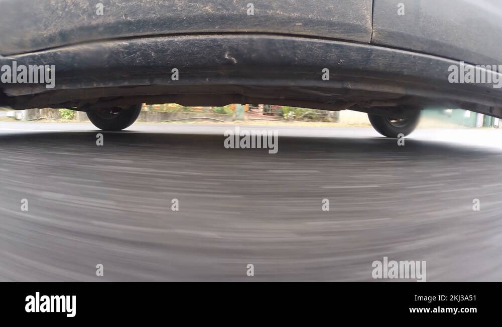 Extreme low side angle of the four wheels of a small car driving on a ...