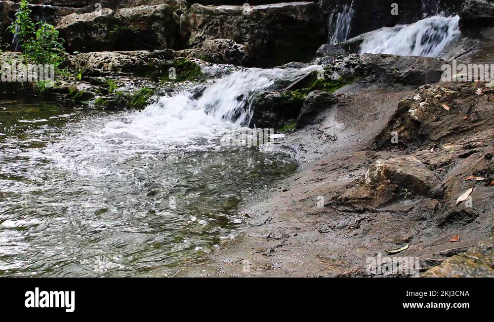 Two sets of waterfalls, one large, one small, empties into a pool of ...