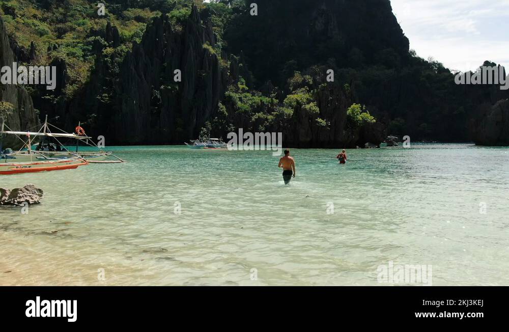Man walking into a pristine blue lagoon in the Philippines Stock Video ...