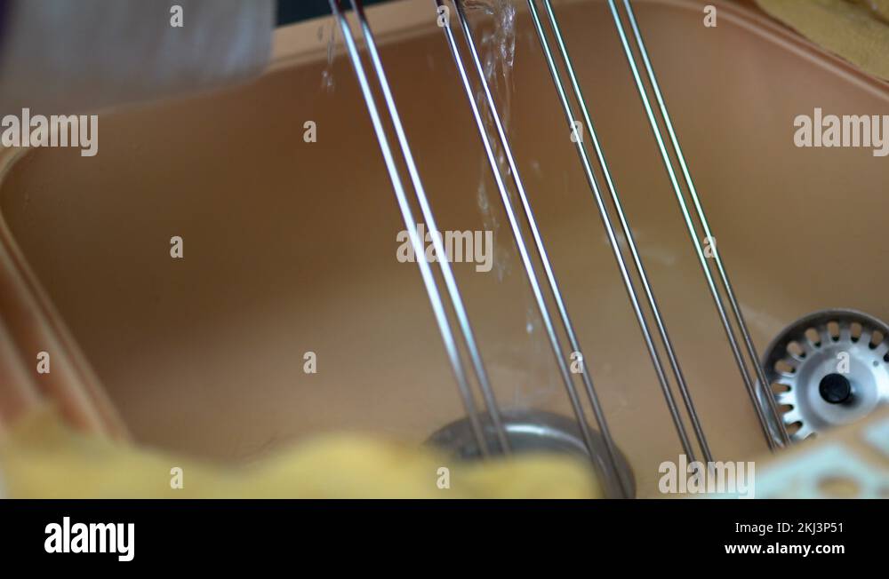 Housewife cleaning metal grates from dirty and greasy spots under the ...