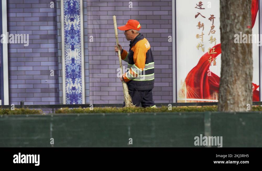 Chinese street sweeper walks past construction site with megaproject ...