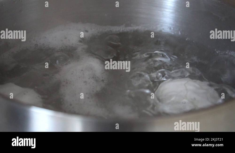 Two eggs cooking in boiling water bubbling heavily, SLOW MOTION Stock ...