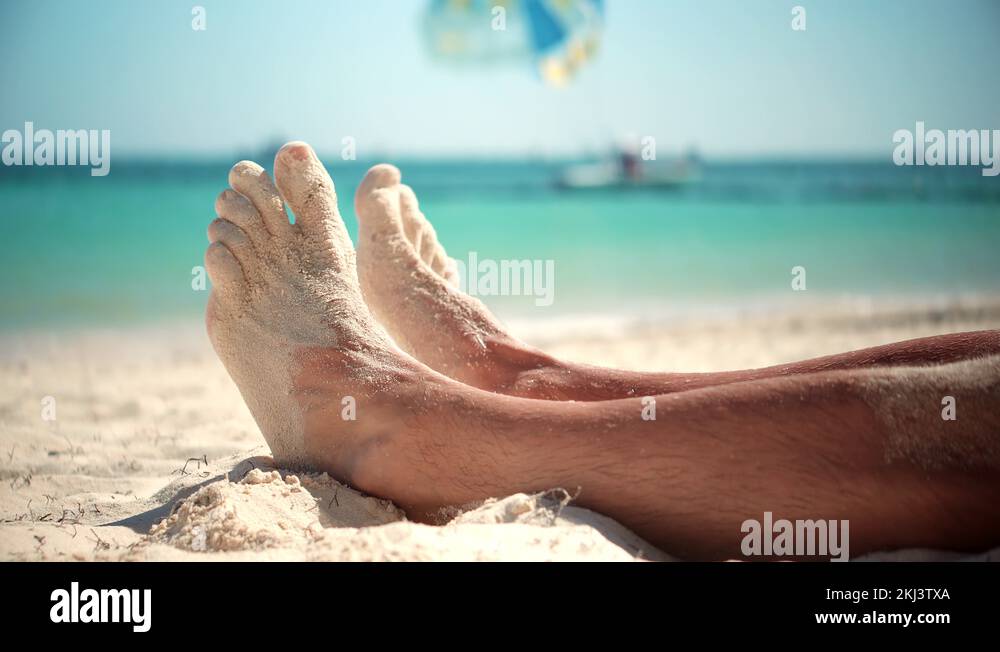 Guy Relaxing Sandy Beach In Sunbed.Man Lying On Beach.Legs On Resort ...