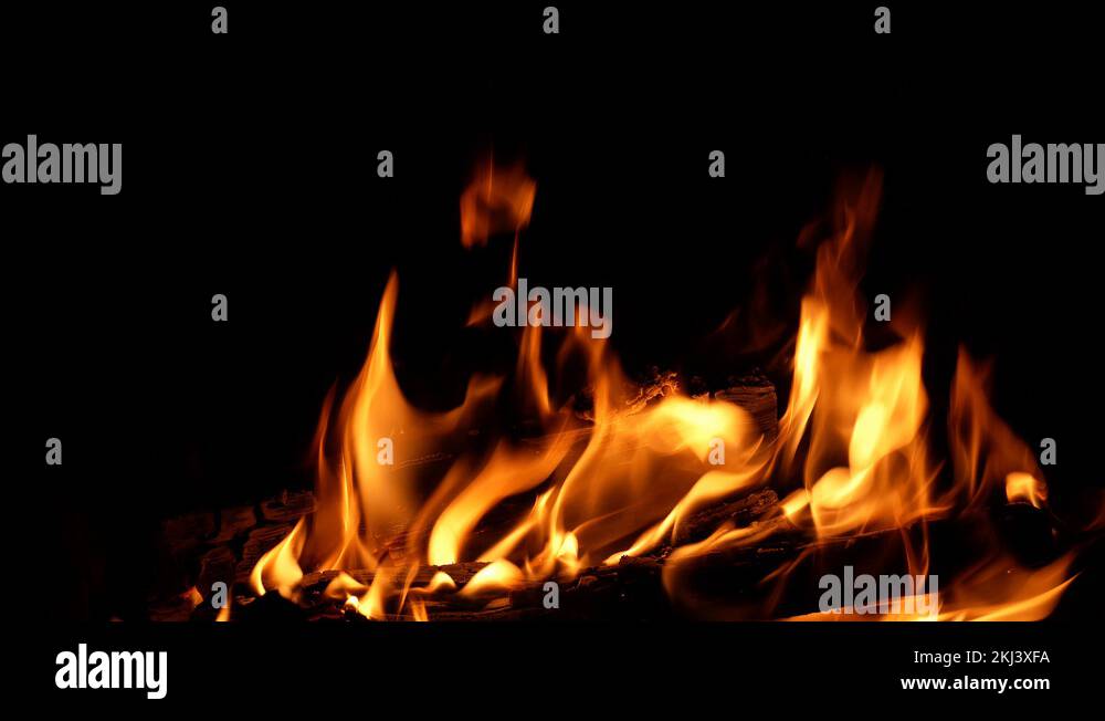 Hot fire and flickering flames from wood logs burning in a fireplace ...