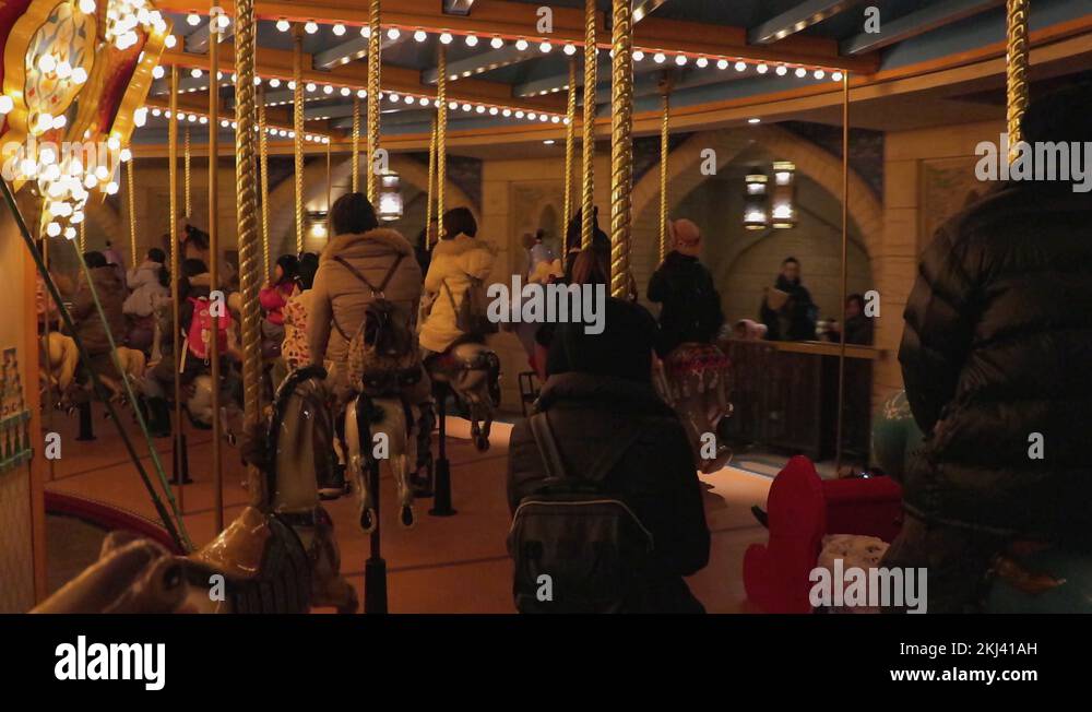 Kids and adults riding the carousel in Tokyo DisneySea at night Stock ...