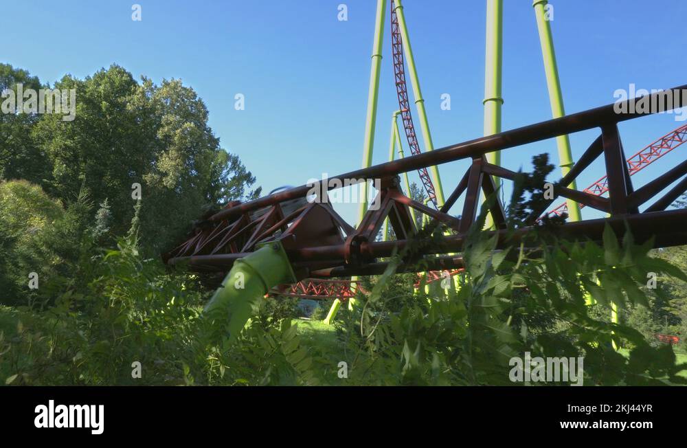 Amusement park visitors ride on roller coaster. Weekend activities ...