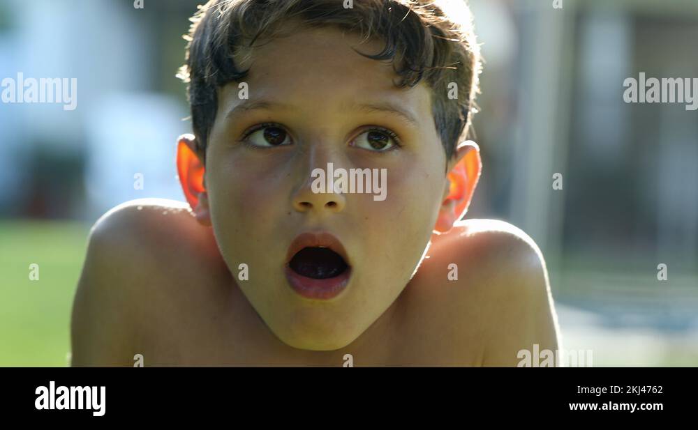 Concerned pensive child boy thinking outside with mouth open in shock ...