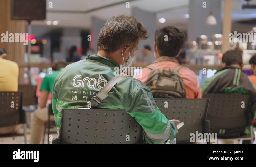 A Grab food rider waiting to order take home menu at a mall in Bangkok ...