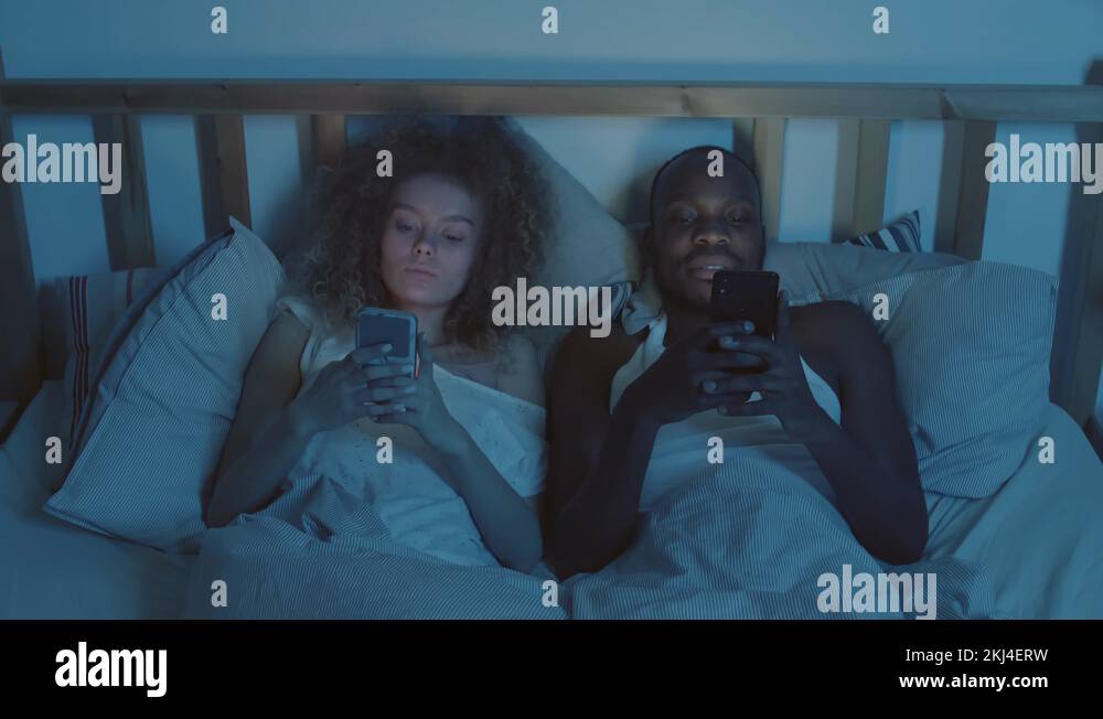 Girlfriend and Boyfriend Using Phones in Bed Stock Video Footage - Alamy
